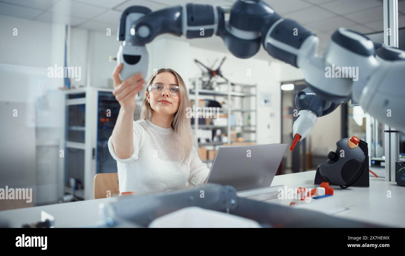 Female Automation Engineer Types on Laptop and Moves Bionic Claw At the ...