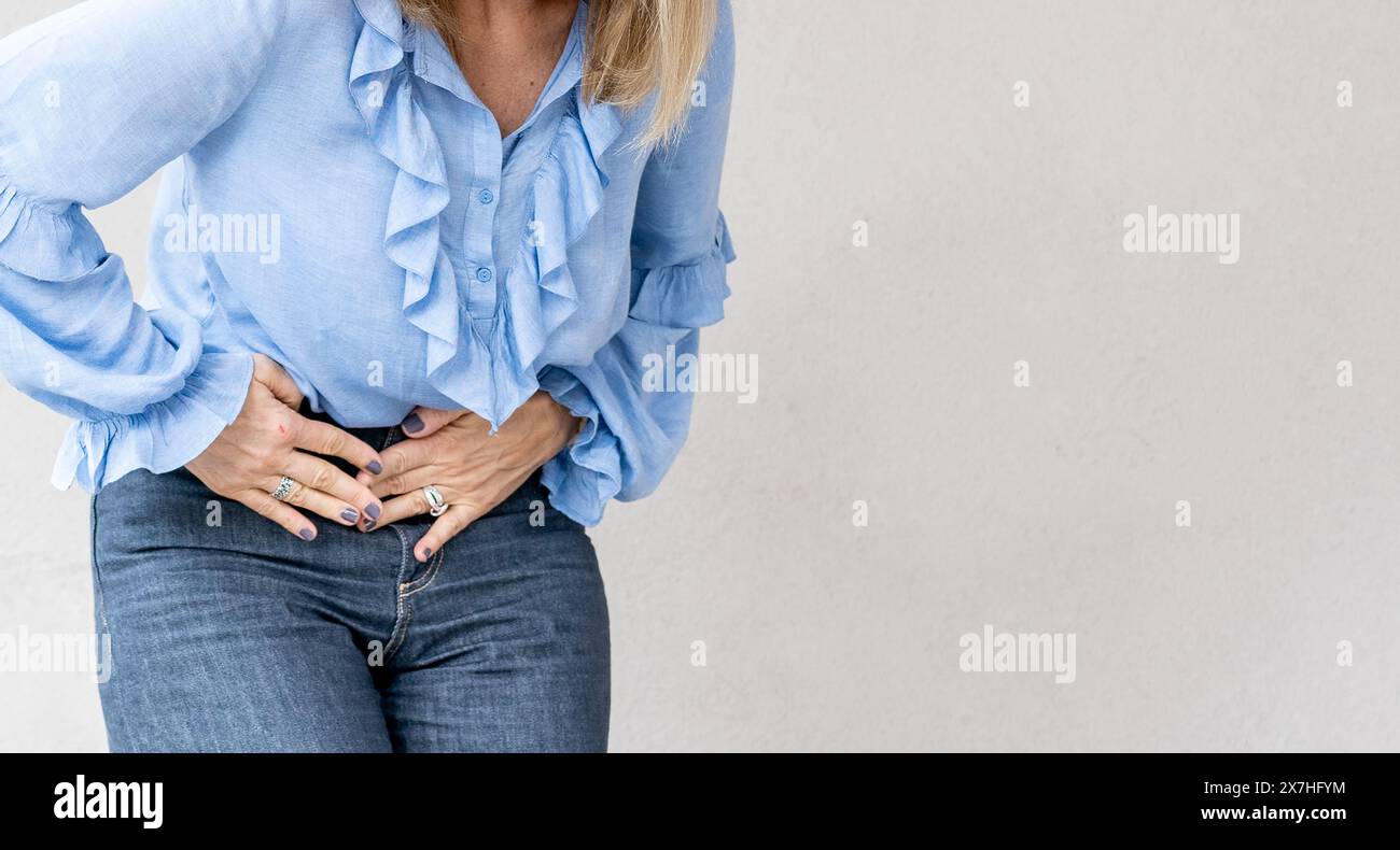Close-up of a woman with stomach ache, menstrual period cramp, or ...