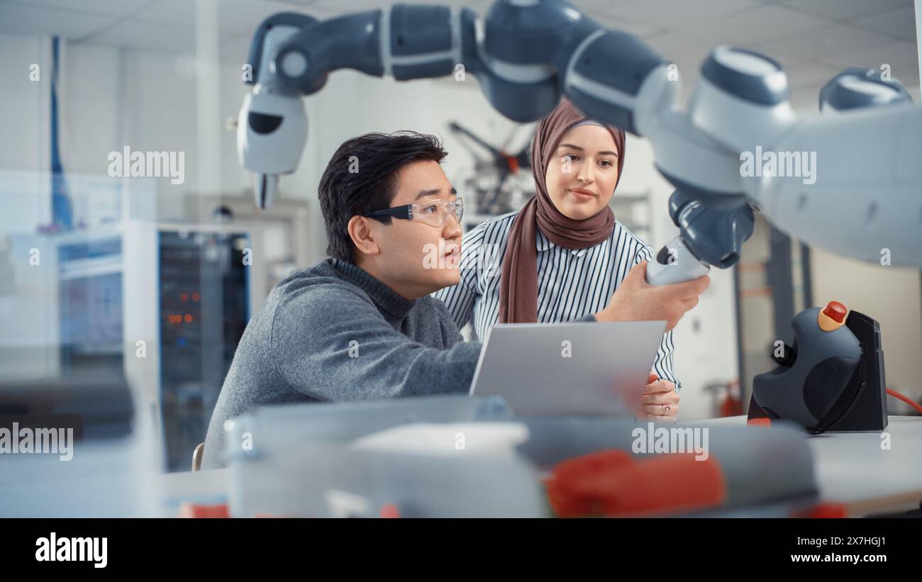 Asian Engineer Repositioning and Examining Robotic Arm with Middle ... Asian Engineer Repositioning and Examining Robotic Arm with Middle ...