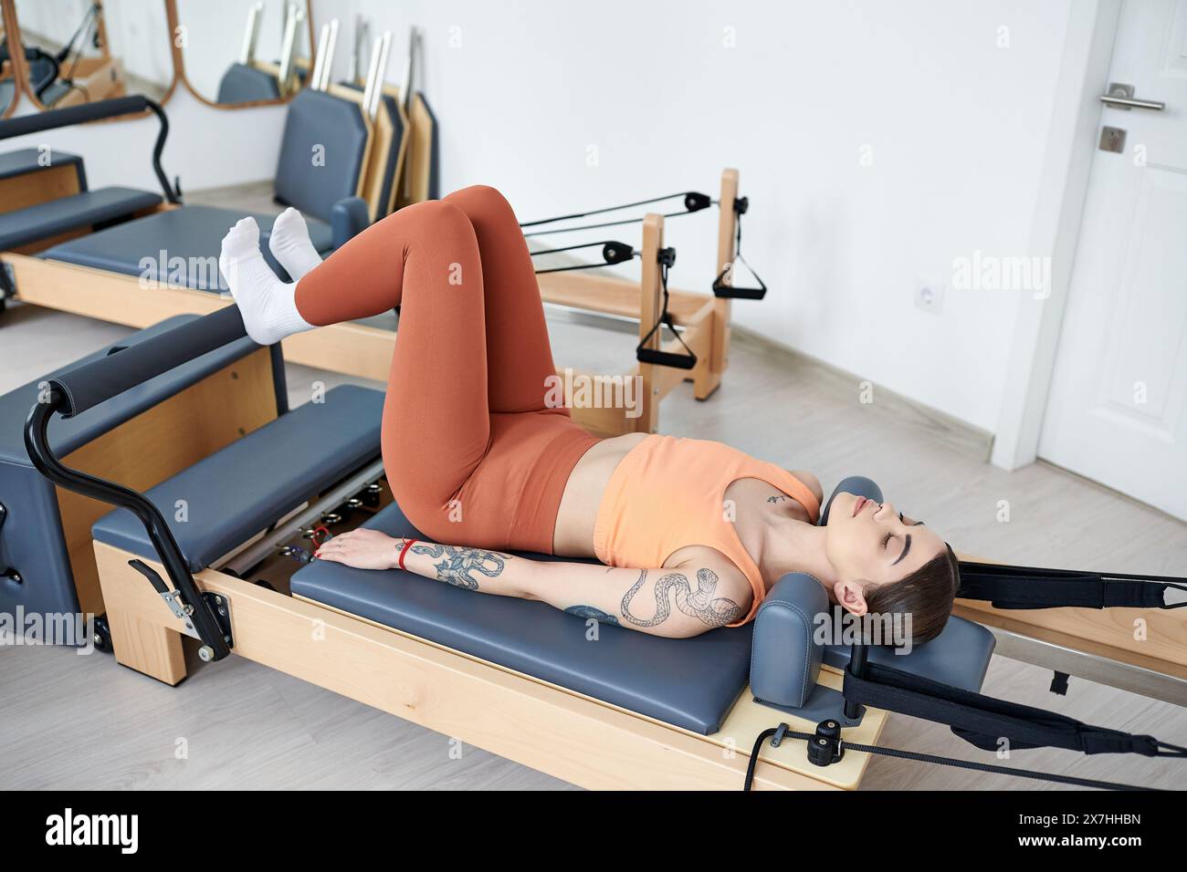 A sporty woman, focusing on engaging her core muscles during a pilates ...