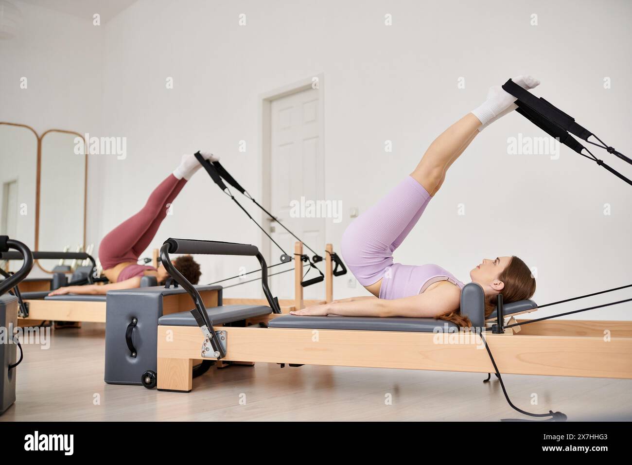 Sporty woman gracefully pivoting on a rowing machine during pilates ...