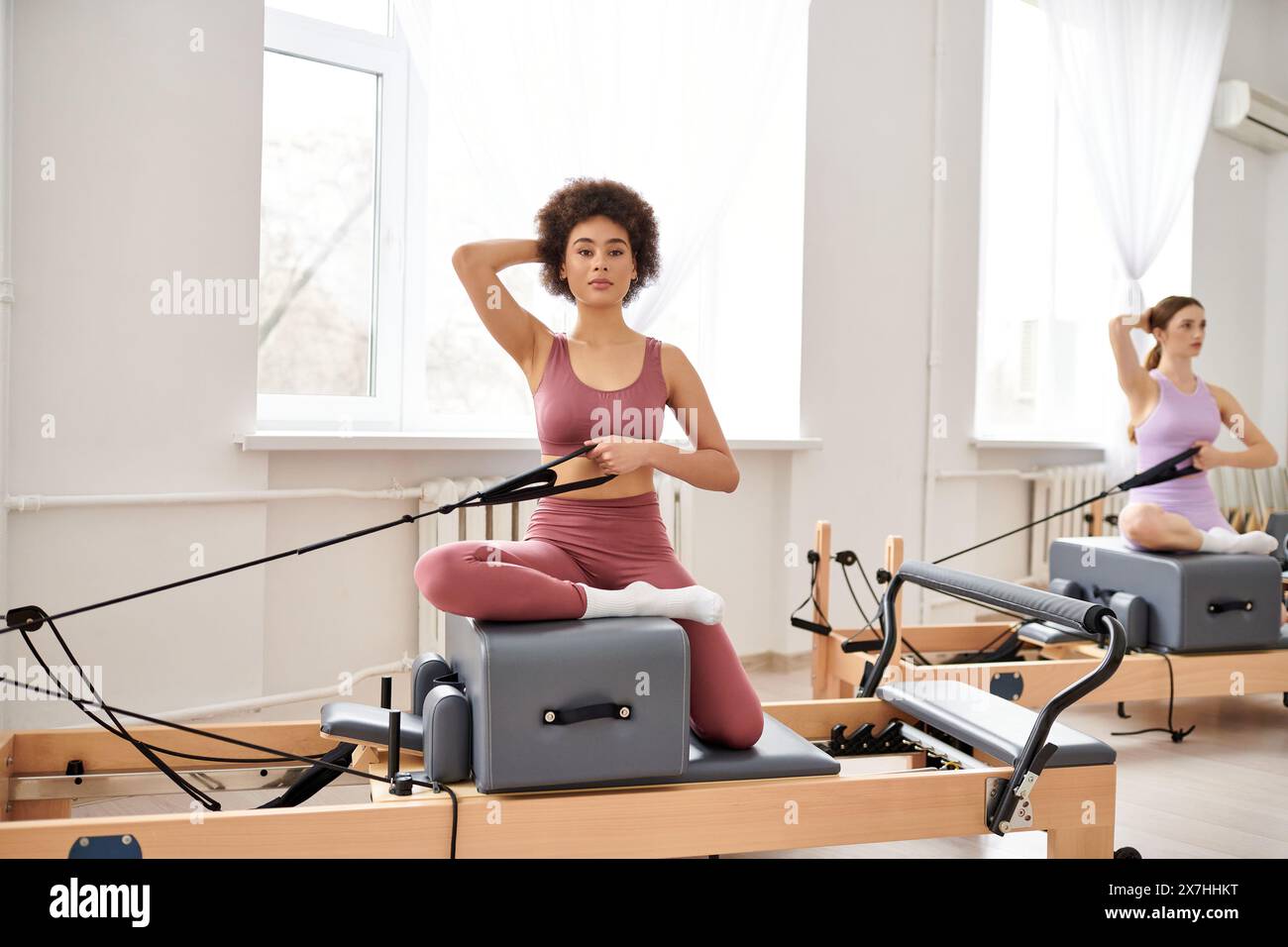 Attractive women engage in a pilates class, focusing on flexibility and ...