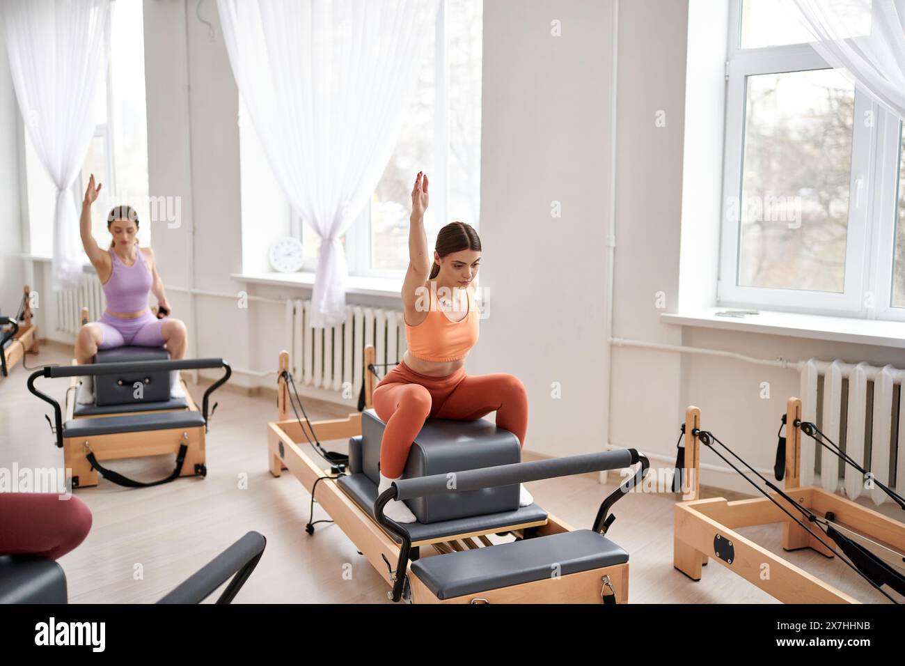 Sporty women performing dynamic exercises during a Pilates lesson Stock ...
