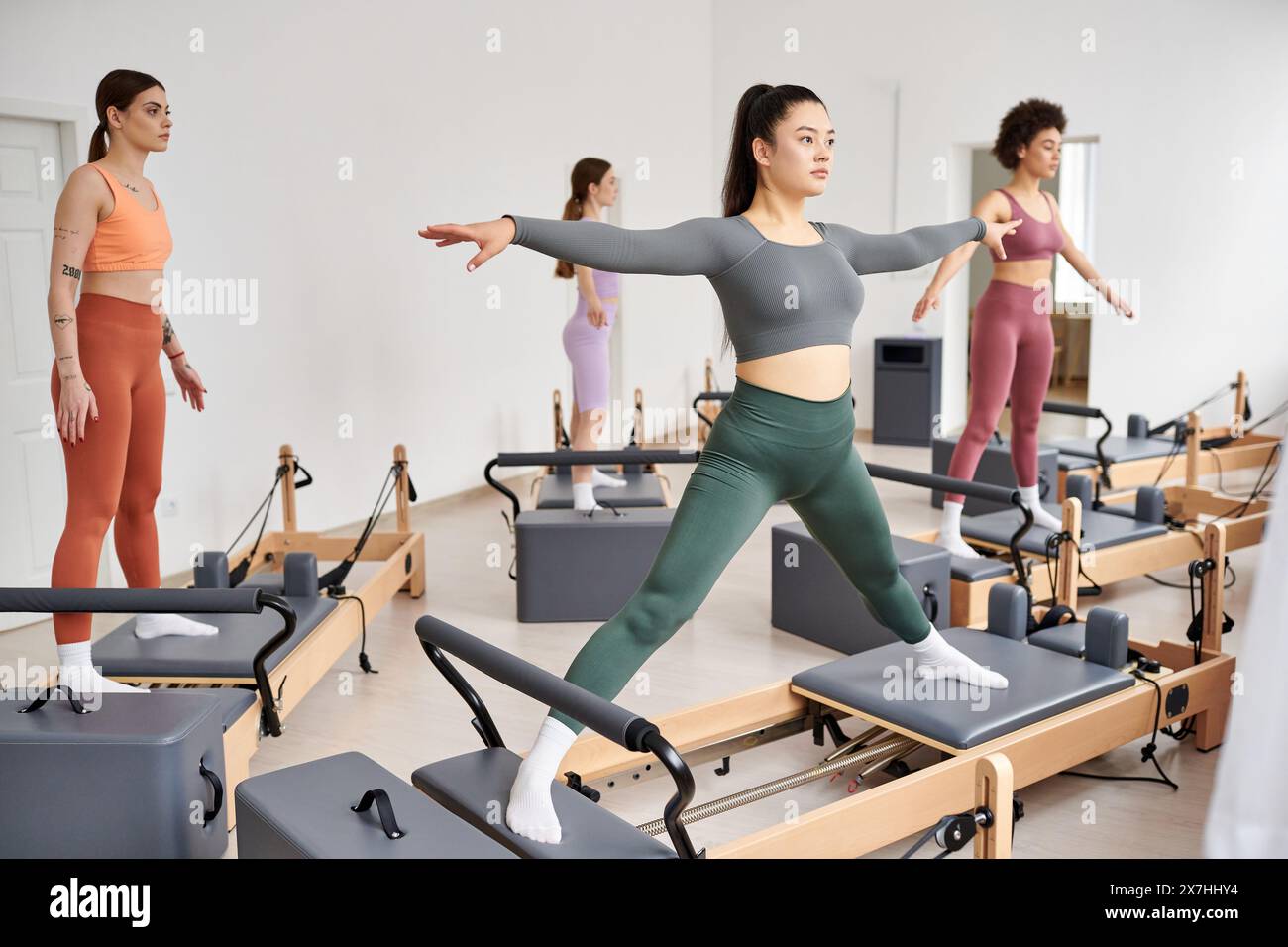 A diverse group of sporty women engaging in a dynamic pilates class ...