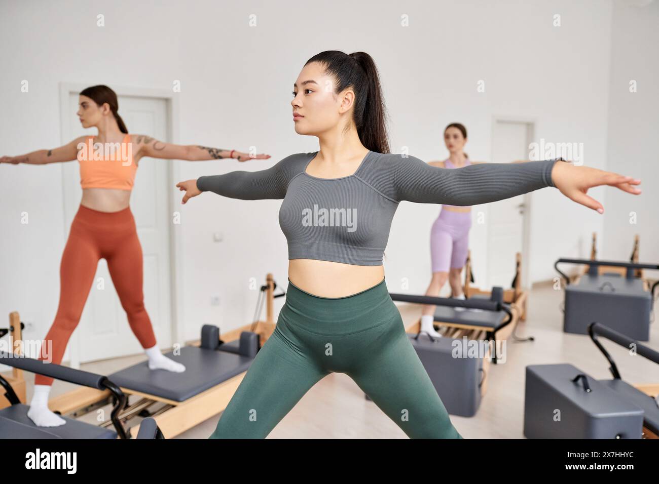 Pretty, sporty women in a gym class enthusiastically participating in a ...