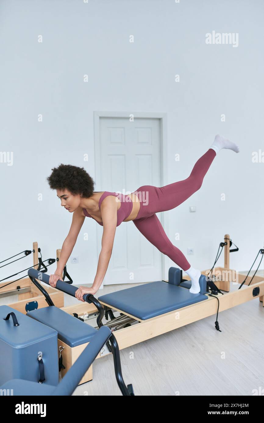 African American woman in pink, rowing machine workout Stock Photo - Alamy