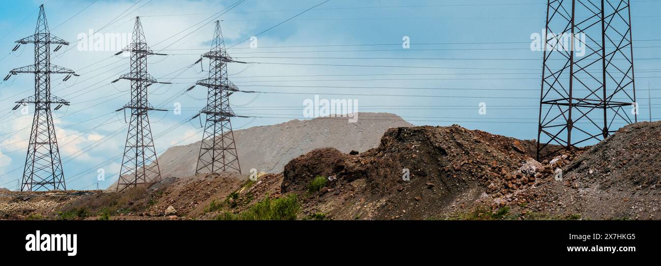 A wide panoramic view of an industrial landscape with power lines and ...