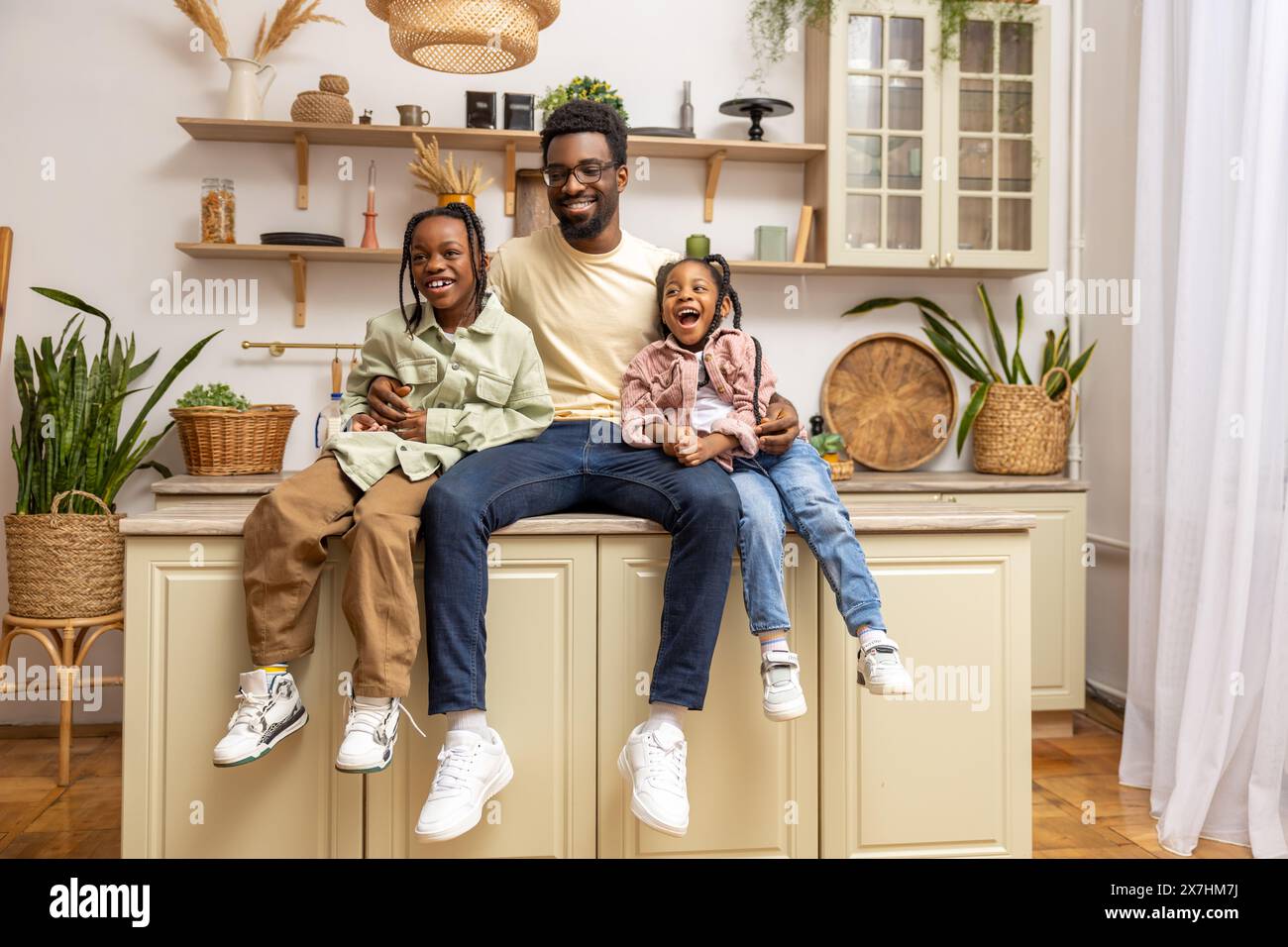 Cheerful dad with happy little children daughters having fun at home ...