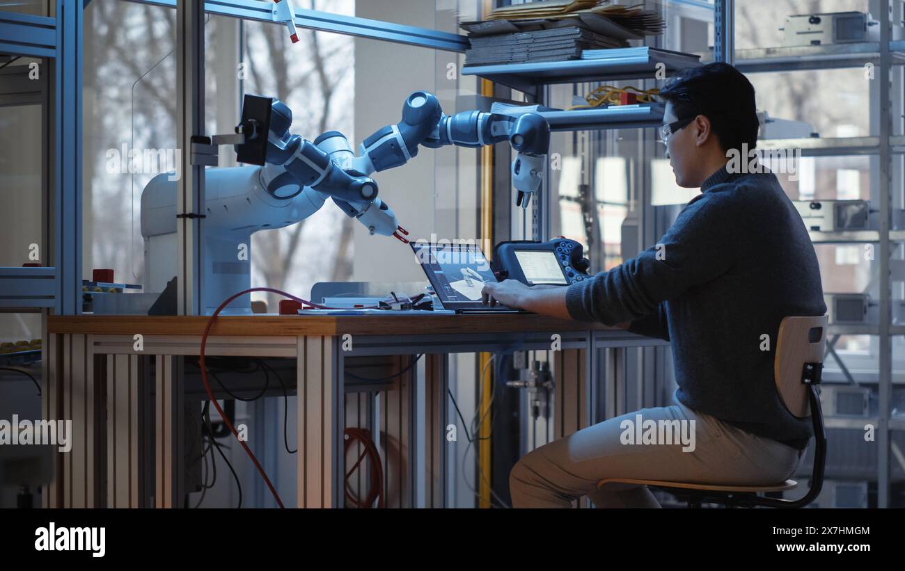 Professional Young Developer Coding on Laptop and Manipulating Robotic ... Professional Young Developer Coding on Laptop and Manipulating Robotic ...