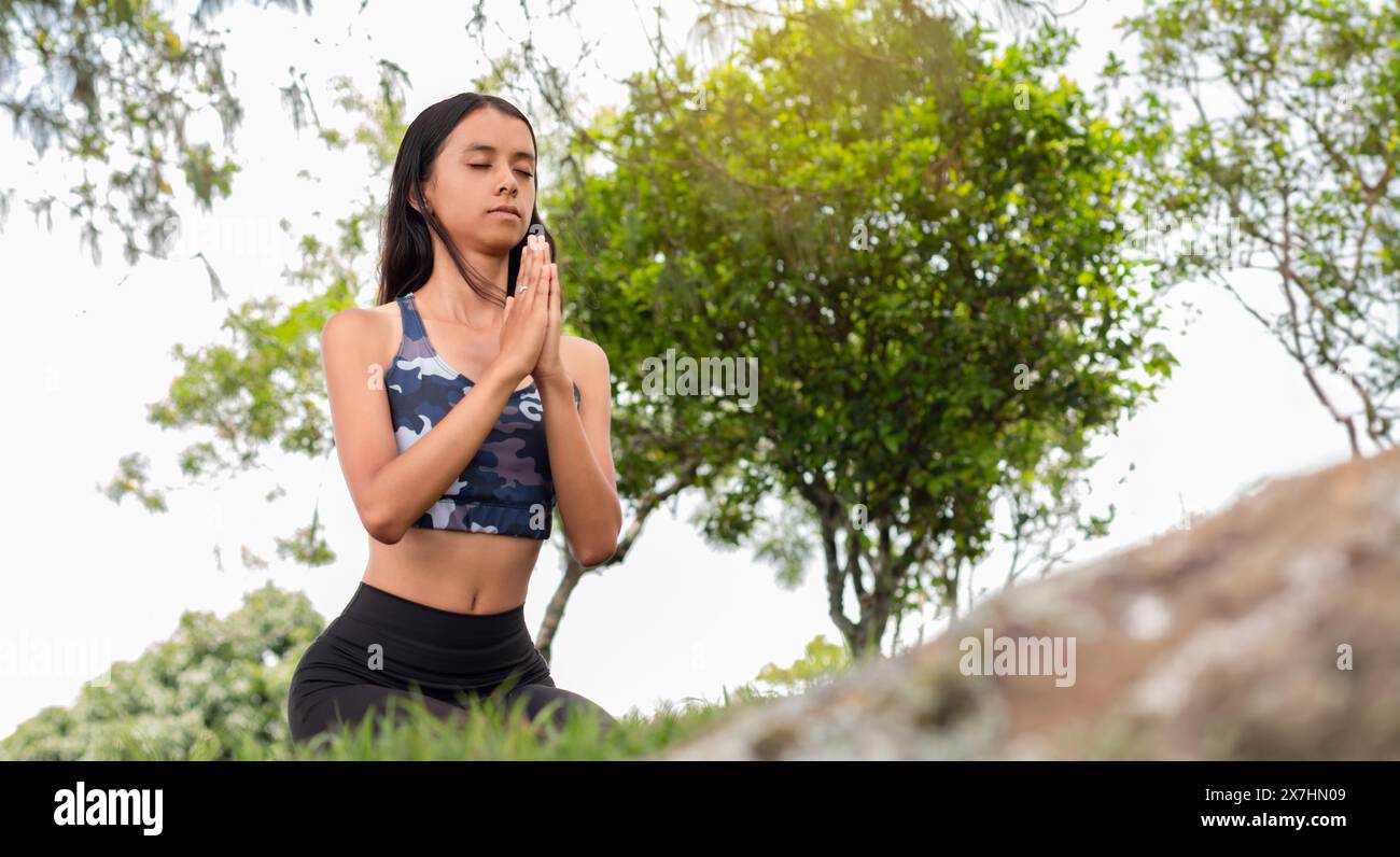 lifestyle: young latina practices lotus flower posture surrounded by ...