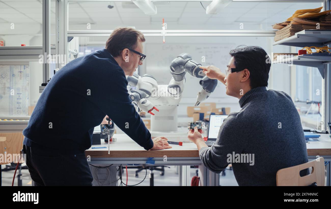 Adult Caucasian Engineer Changes Position of Robotic Arm with ...