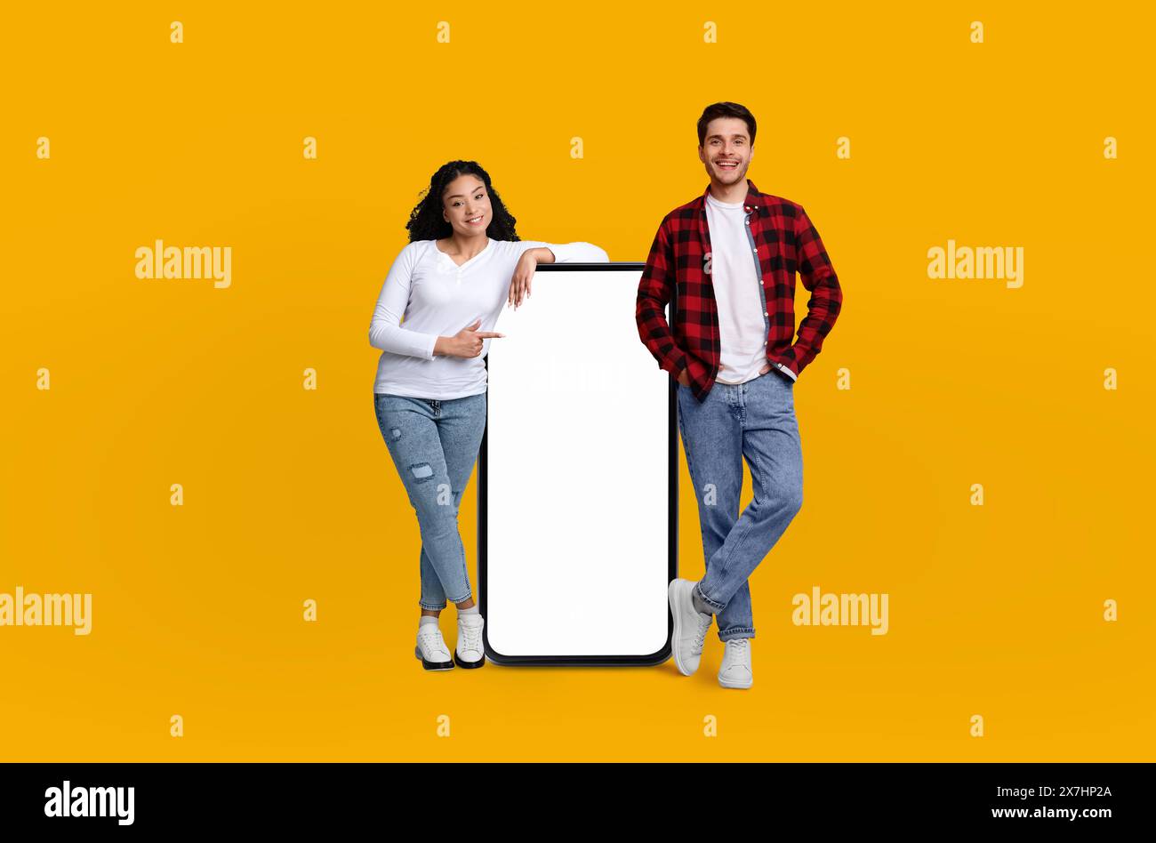 Multiracial couple stand next to large smartphone Stock Photo - Alamy