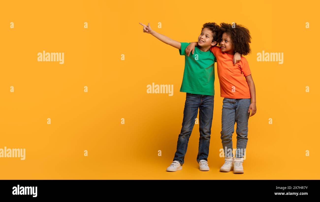 Two Children Pointing at Something on a Yellow Background Stock Photo ...