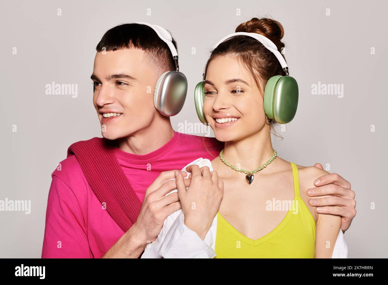 A stylish young couple in love, listening to music with headphones on ...