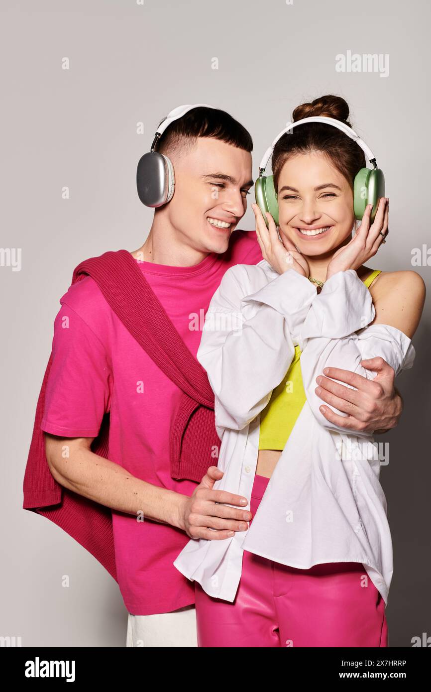 A stylish young couple in love listening to music together, wearing ...