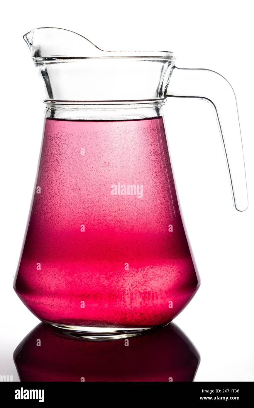 Transparent glass jug with red, translucent drink. A pitcher on a white ...