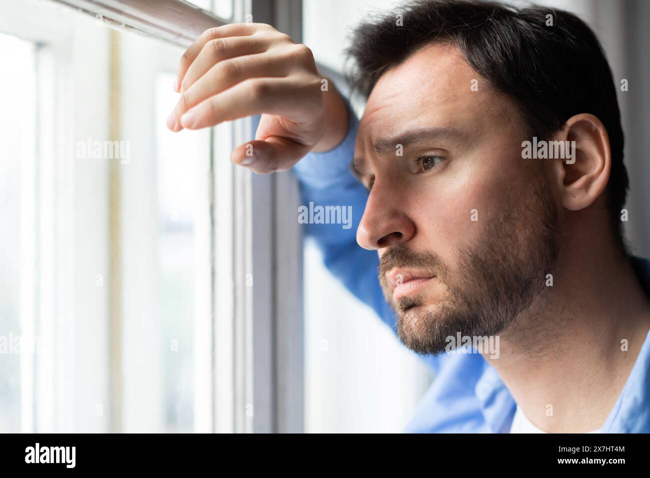 Sad Man Looking Out of a Window Stock Photo - Alamy