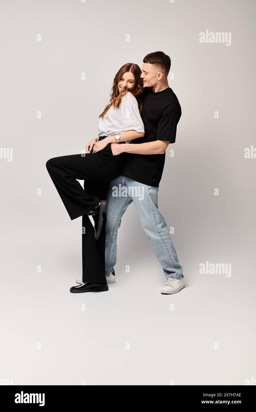 A man tenderly holds a woman in his arms, expressing love and affection ...