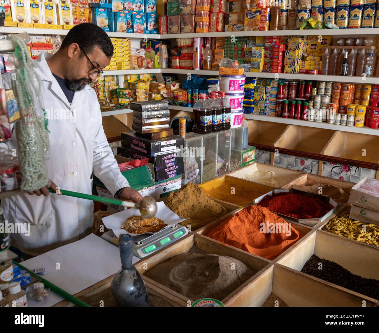 Er-Rich, Morocco - 7 March, 2024: Moroccan shopkeeper mixing spices in ...