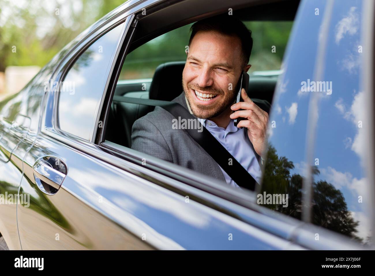Man chuckles merrily during a car ride, enjoying a lively conversation ...