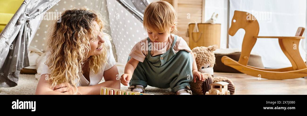 A curly-haired mother and her toddler daughter engage in playful ...