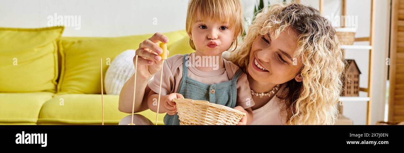 A curly mother tenderly holds her toddler daughter in her arms ...