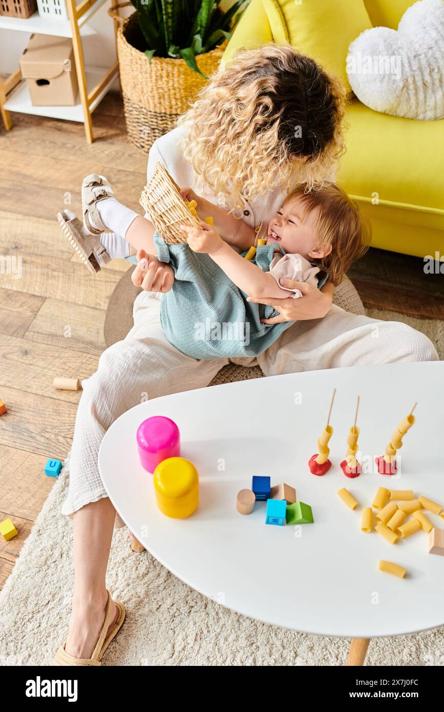 a mother and her daughter, happily playing with dry pasta in a cozy ...