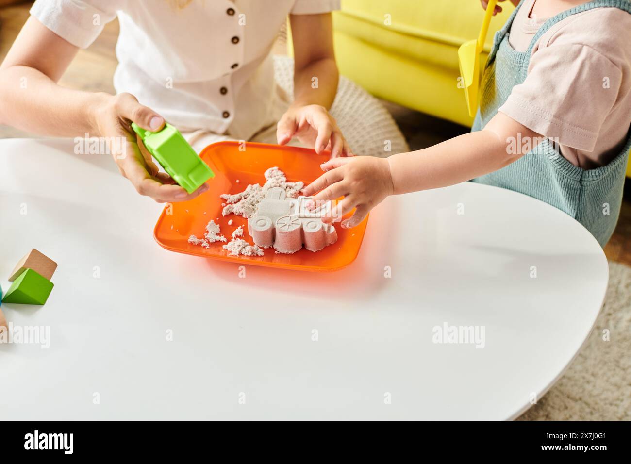 Two children, a toddler girl with curly hair and an older child, play ...