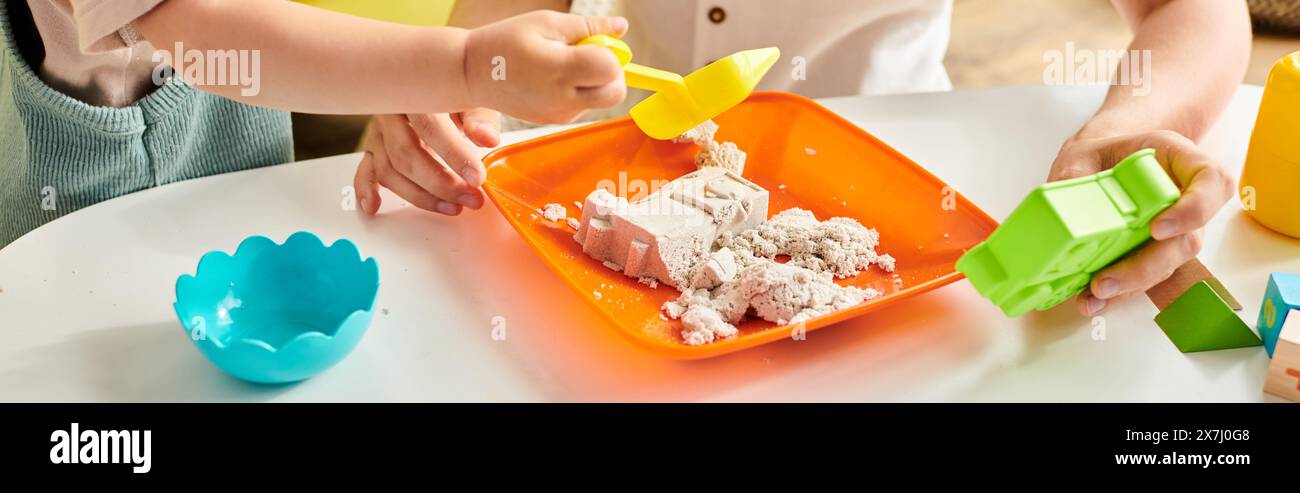 Toddler girl exploring and playing with a plastic container of food in ...