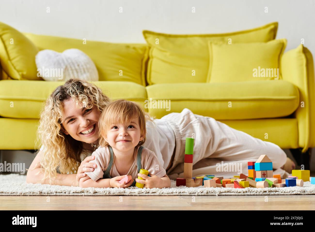 A curly mother and her toddler daughter engage in Montessori learning ...