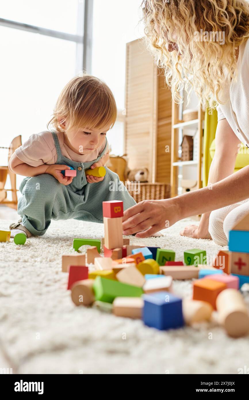 A curly mother and her toddler daughter engage in educational play ...