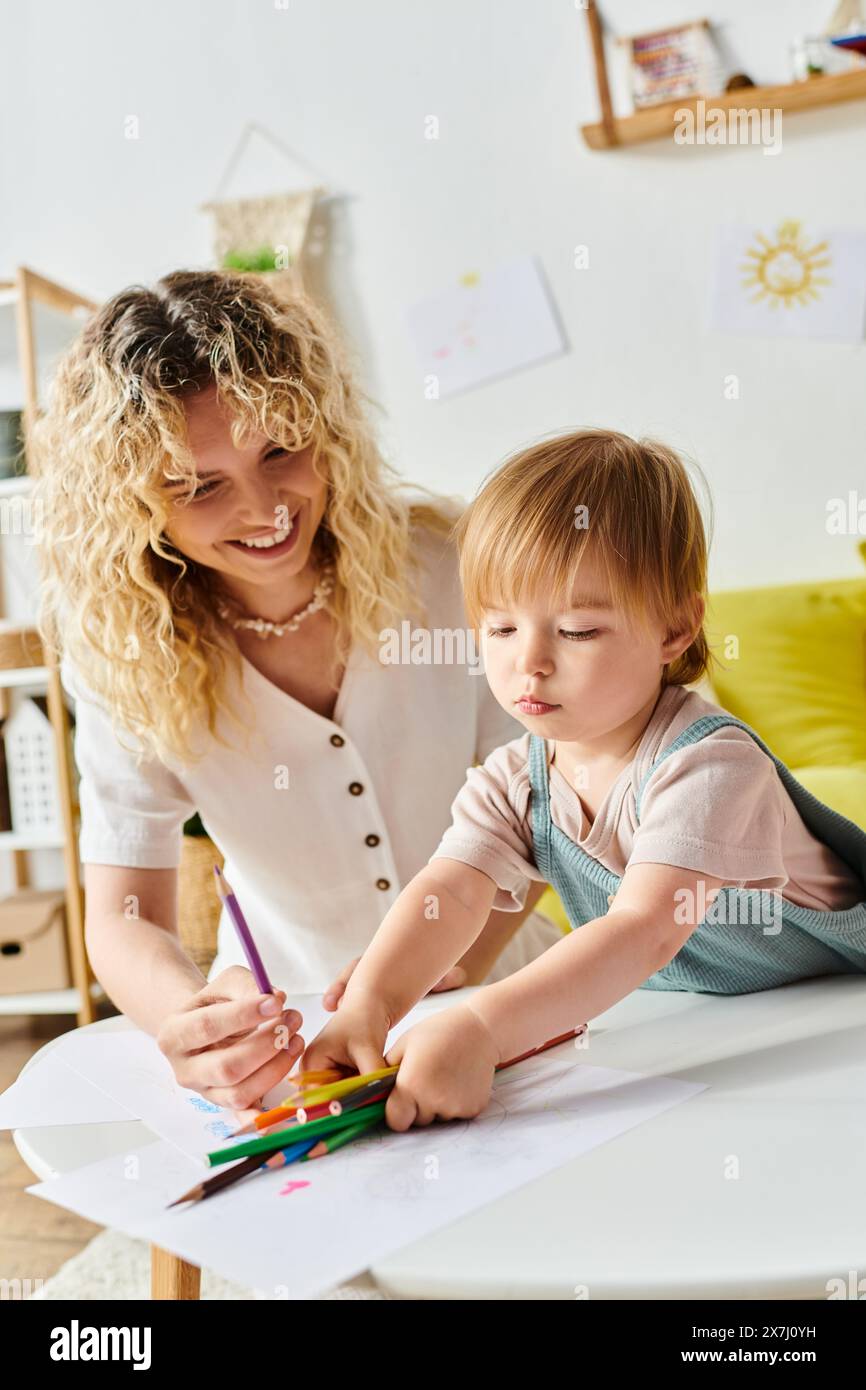 Curly-haired mother gently guides her toddler daughters hand while ...