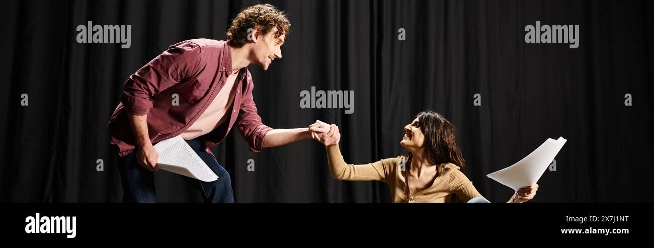 Handsome man and woman rehearse lines on stage, holding scripts Stock ...