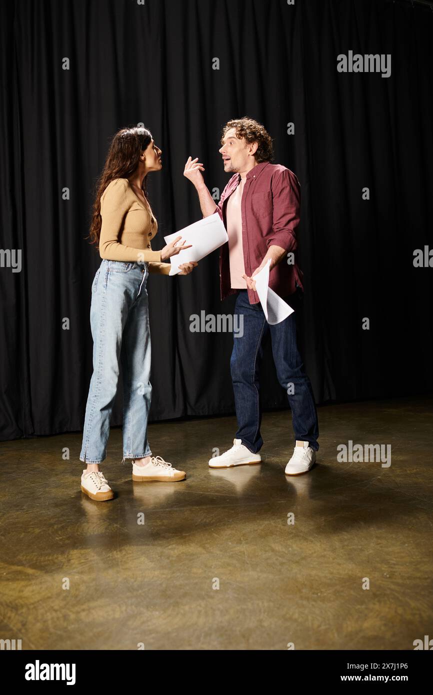 A handsome man and a woman standing together on stage during rehearsals ...