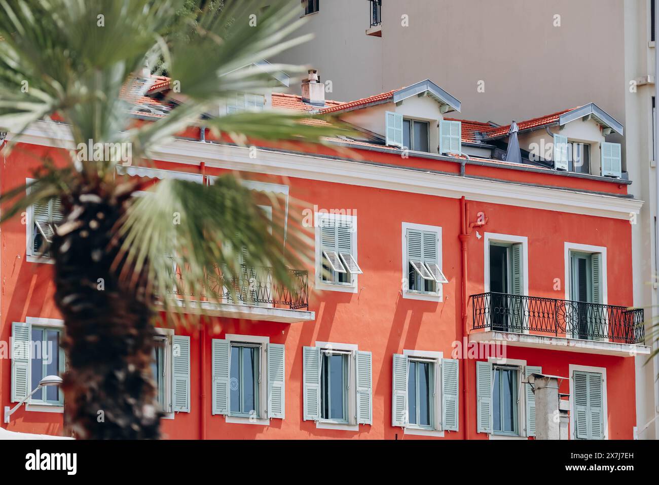 Bright red southern facades of Nice and typical windows with shutters ...