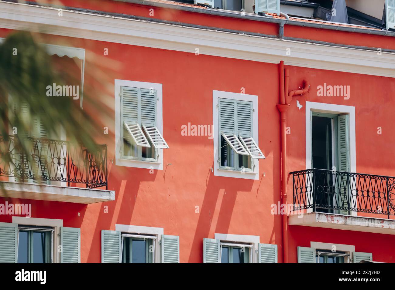 Bright red southern facades of Nice and typical windows with shutters ...