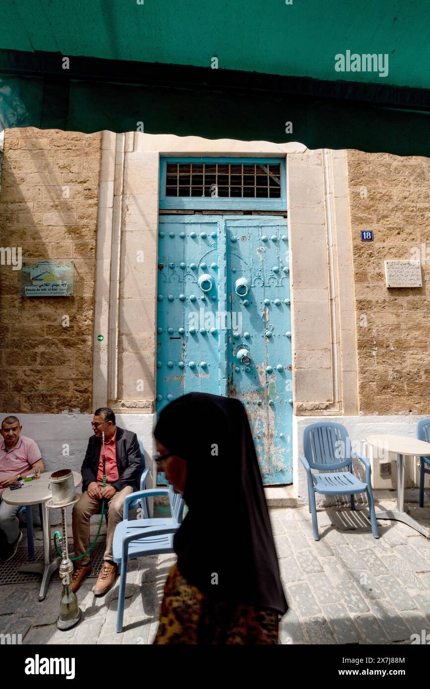 Tunis, Tunisia. 13th May 2024 An old wooden blue door with Tunisian men ...