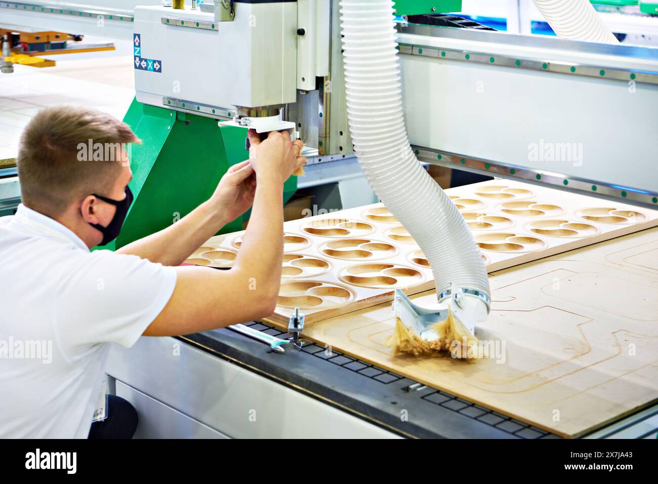 A man worker on a CNC milling and engraving machine at the exhibition ...