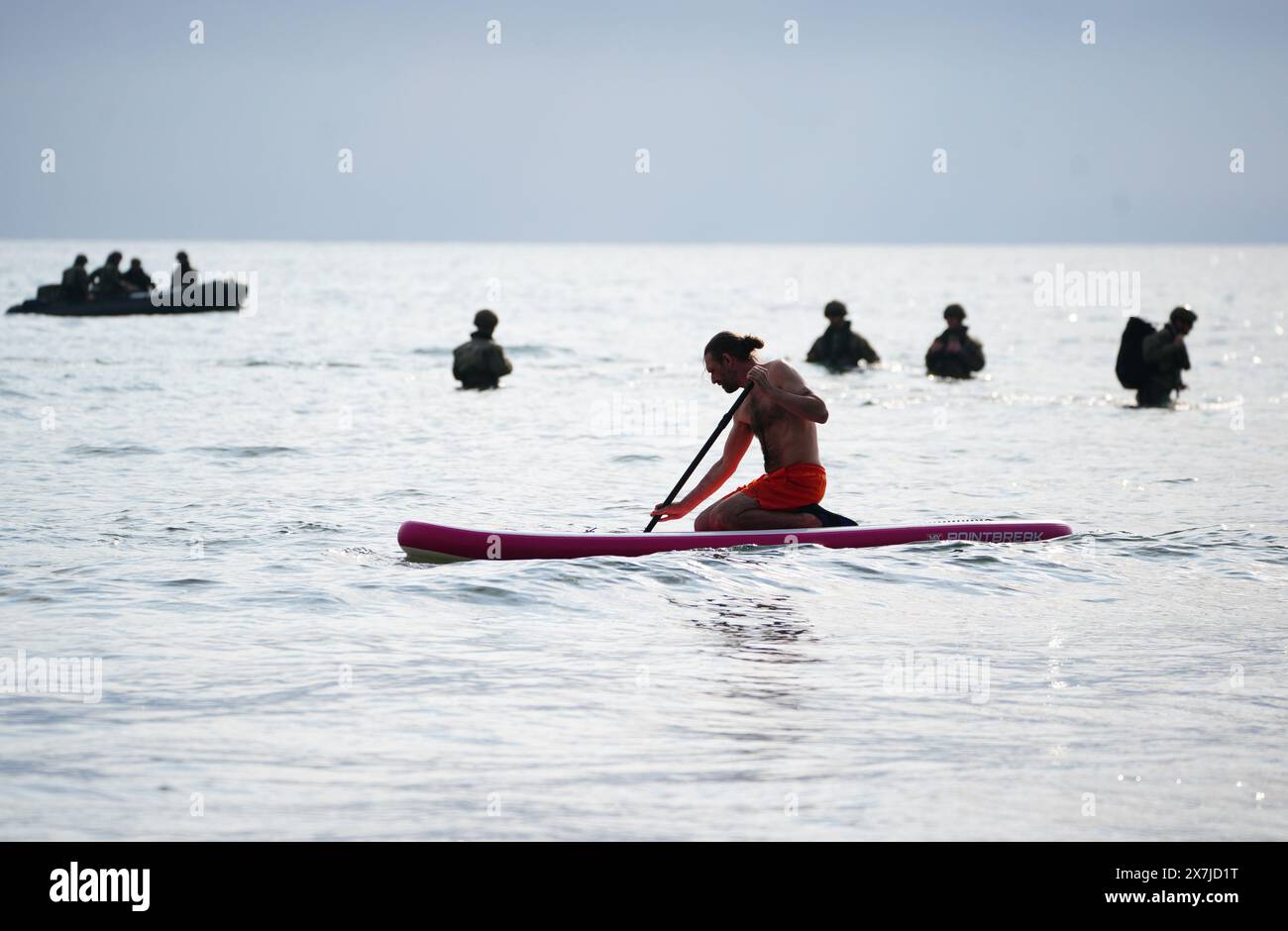 A puddle boarder passes members of Armed Forces personnel from 47 ...