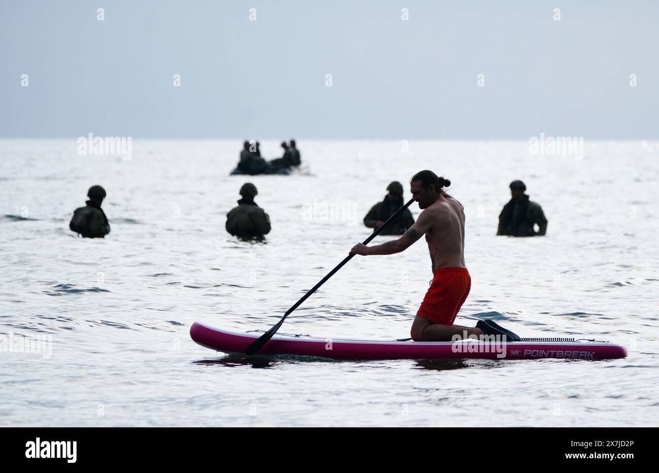 A puddle boarder passes members of Armed Forces personnel from 47 ...