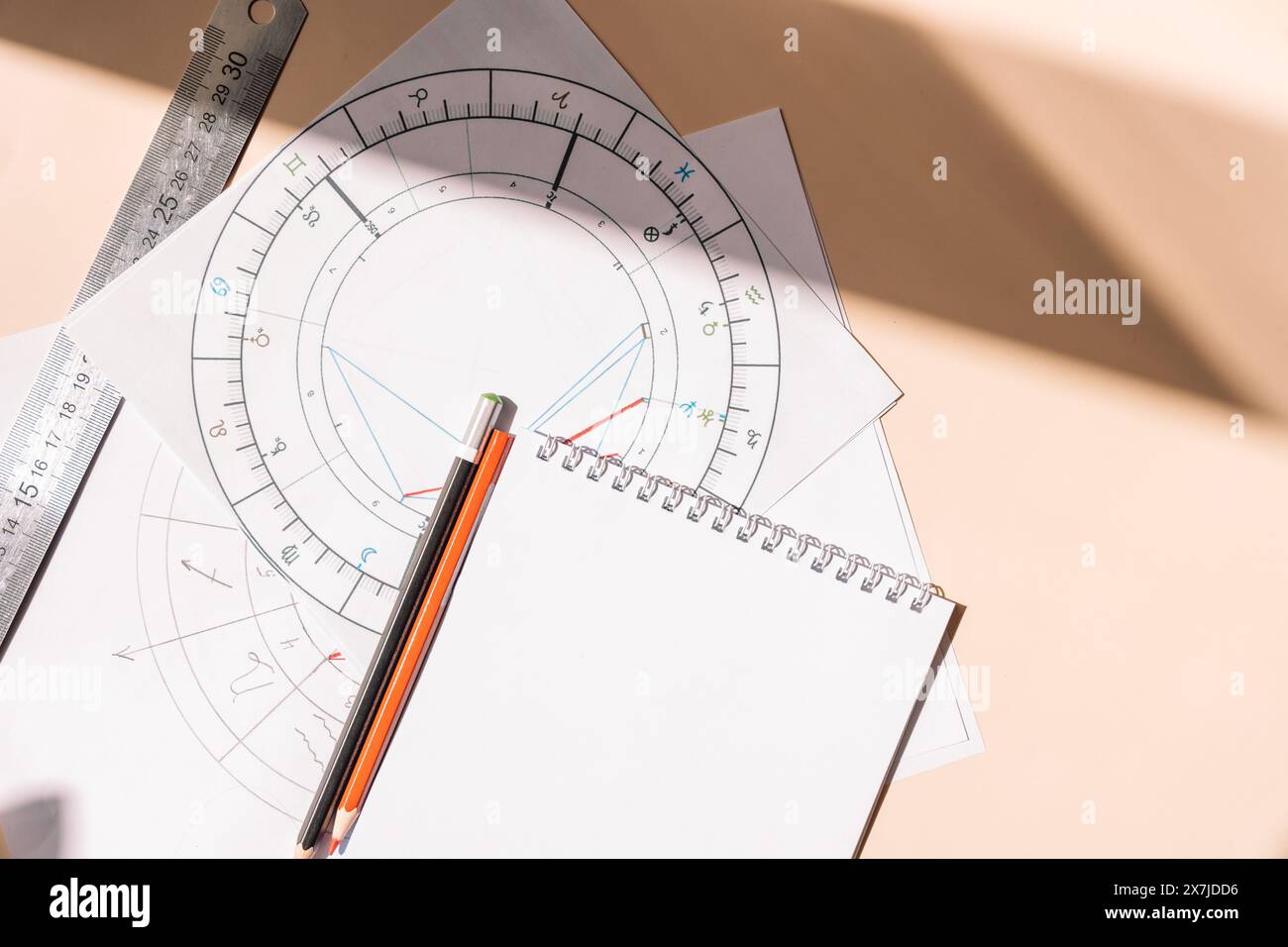 Natal chart on white paper with pencils and ruler on an orange ...