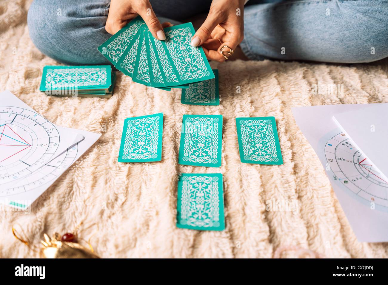 Lady laying out tarot cards with green cover while sitting on bed Stock ...