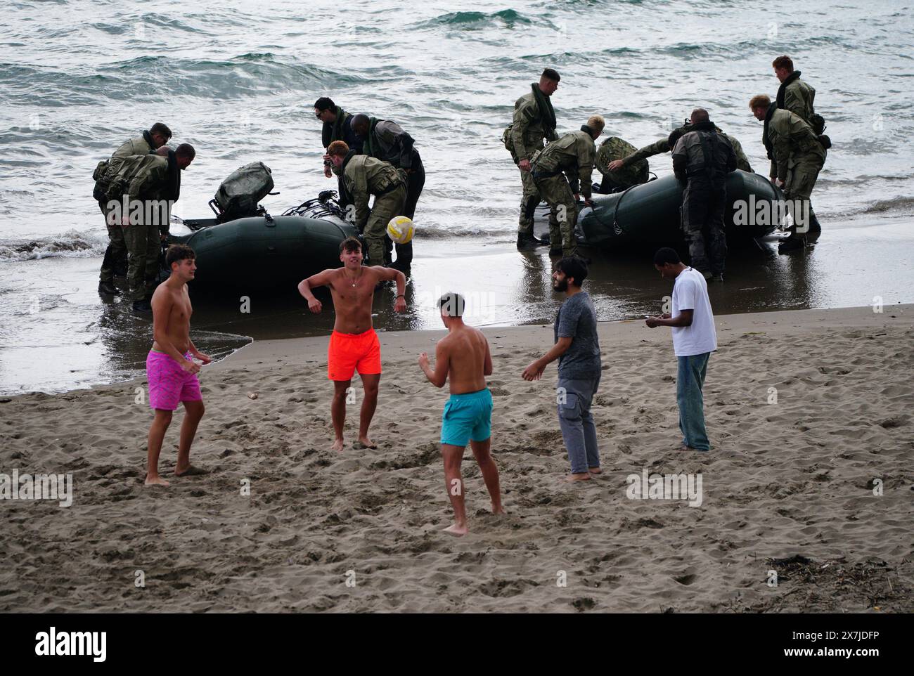 People play on the beach as members of Armed Forces personnel from 47 Commando (Raiding Group ...