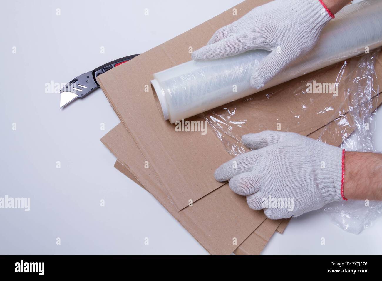 Packing the goods in a cardboard box and stretch film. Tools for ...