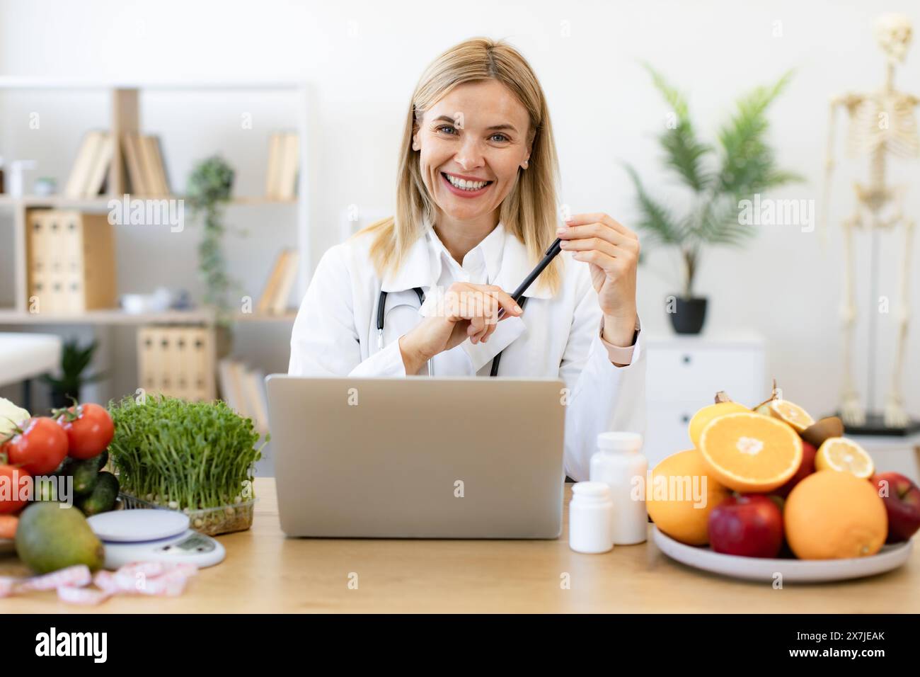 Dietitian working with laptop computer making balanced corrective diet ...