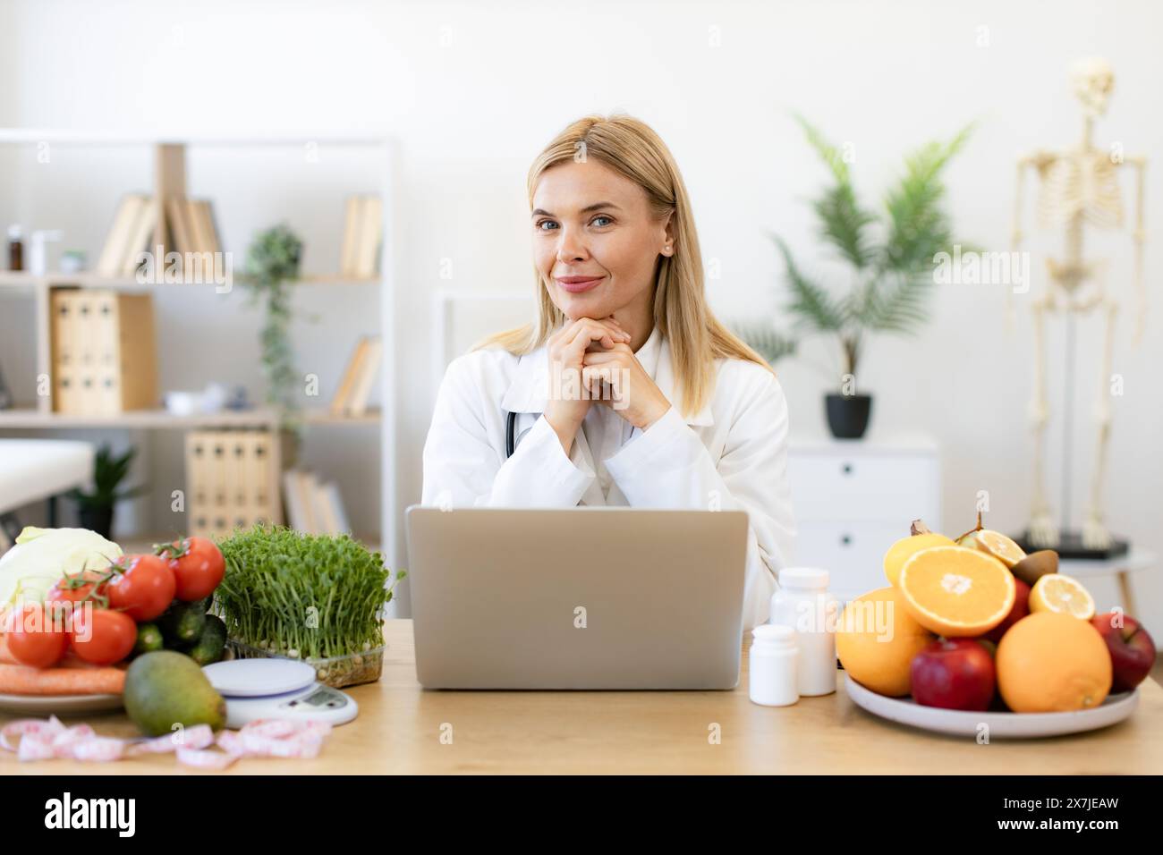 Nutritionist working on laptop and writing diet plan for patient Stock ...