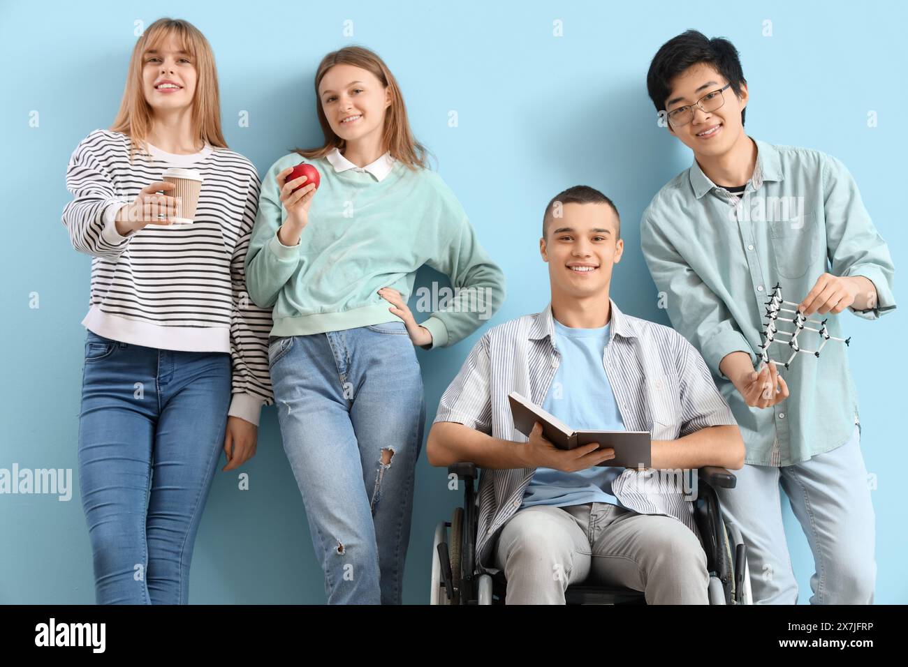 Group of teenagers with boy in wheelchair on blue background Stock ...