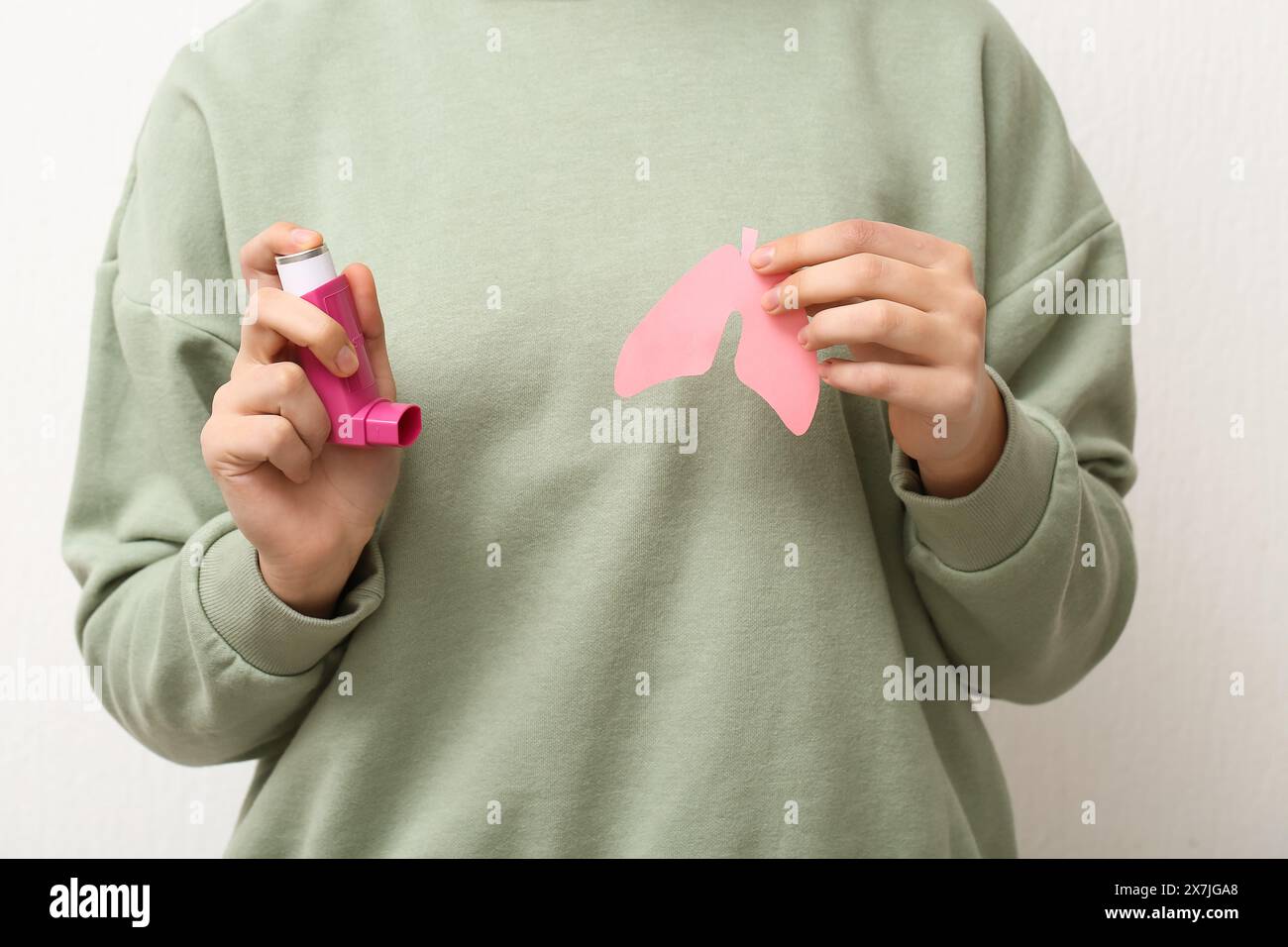 Young woman with paper lungs and asthma inhaler on white background ...