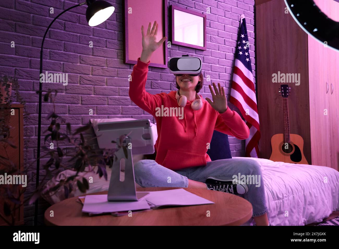 Female student using VR glasses in bedroom at night Stock Photo - Alamy