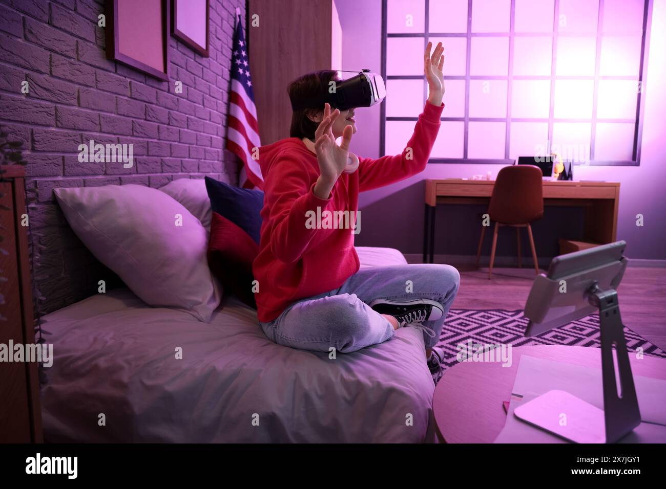 Female student using VR glasses in bedroom at night Stock Photo - Alamy
